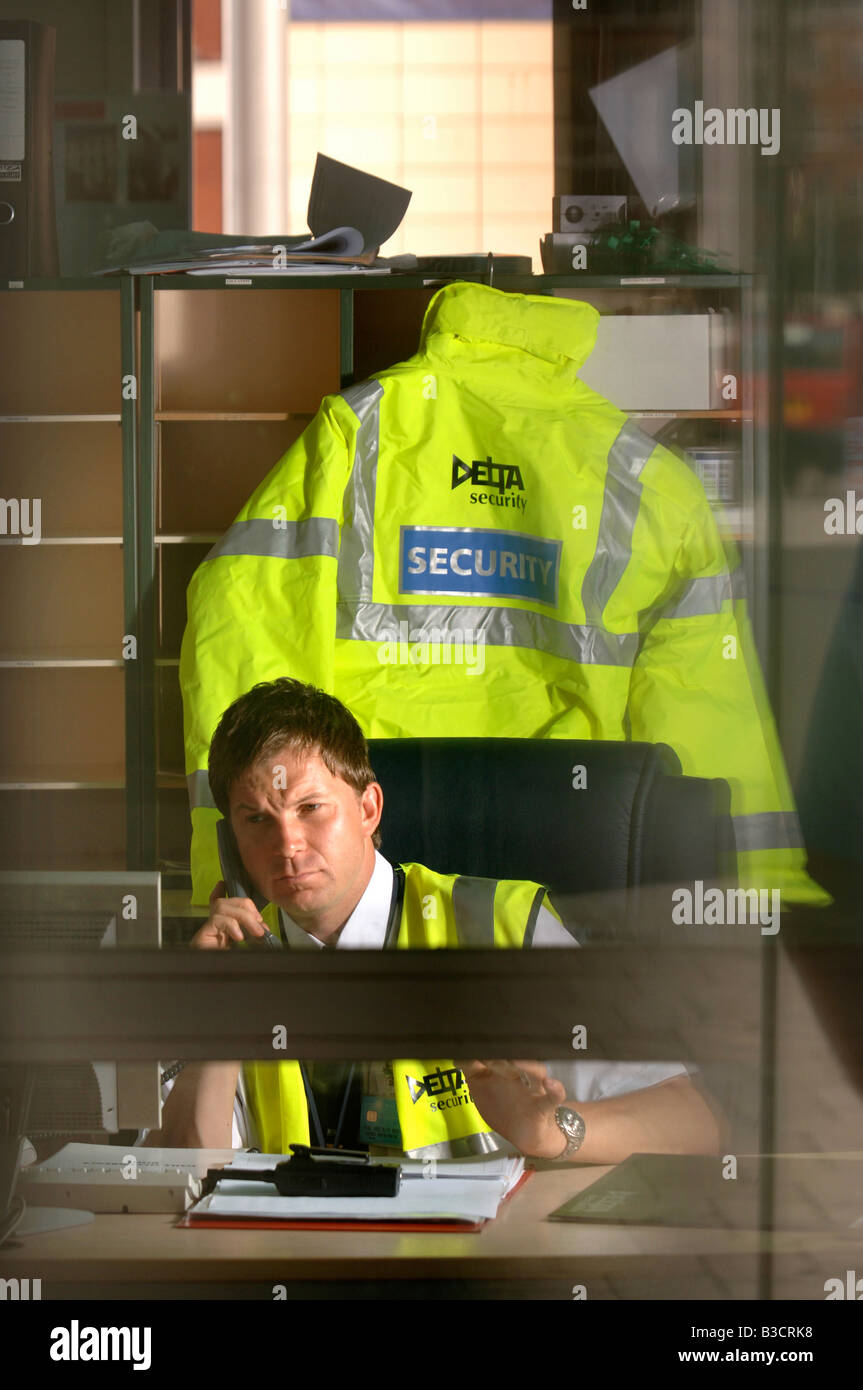 A SECURITY GUARD LOGS INFORMATION AT AN OFFICE DESK UK Stock Photo - Alamy