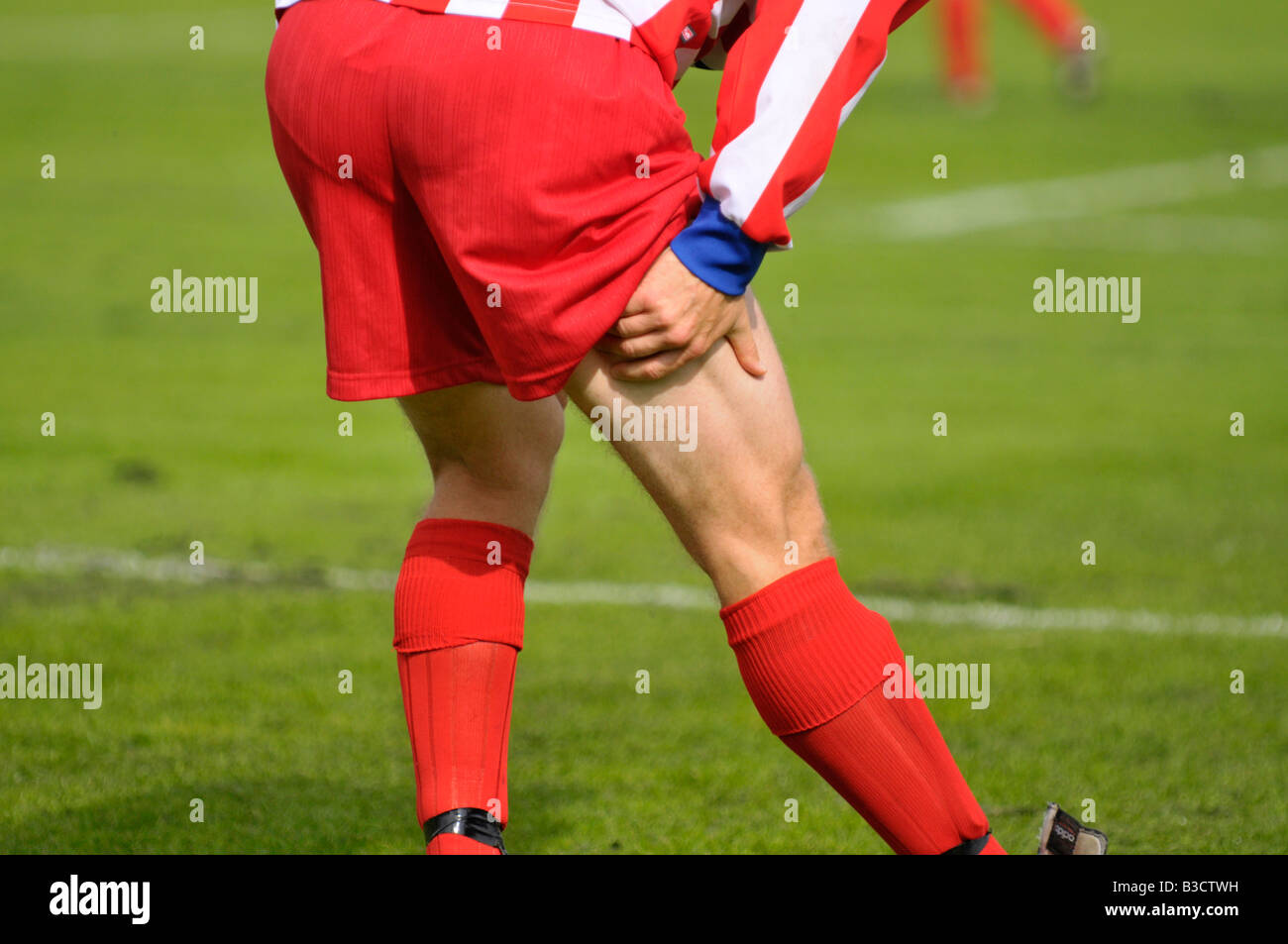 footballer holds his painful hamstring Stock Photo - Alamy