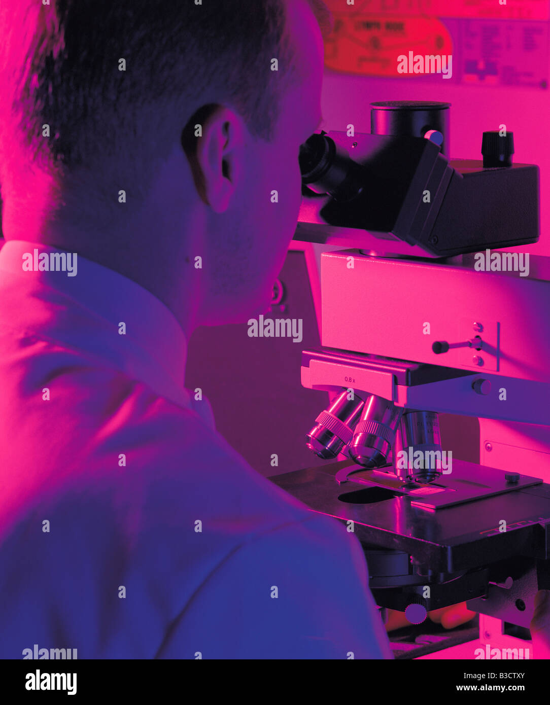 Technician looking through microscope in hospital laboratory Stock ...
