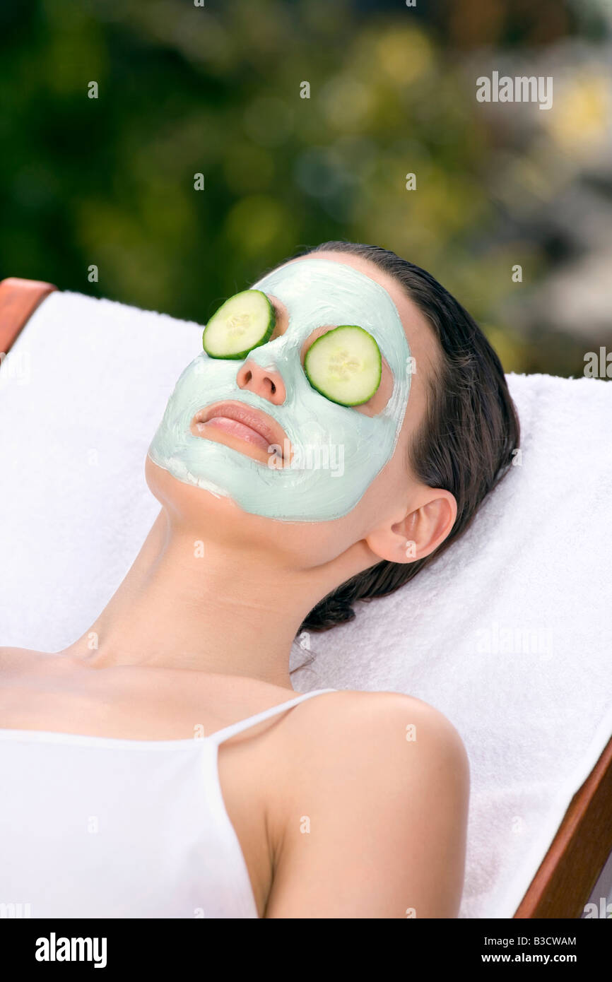 Young woman with face mask and cucumber slices, portrait Stock Photo ...