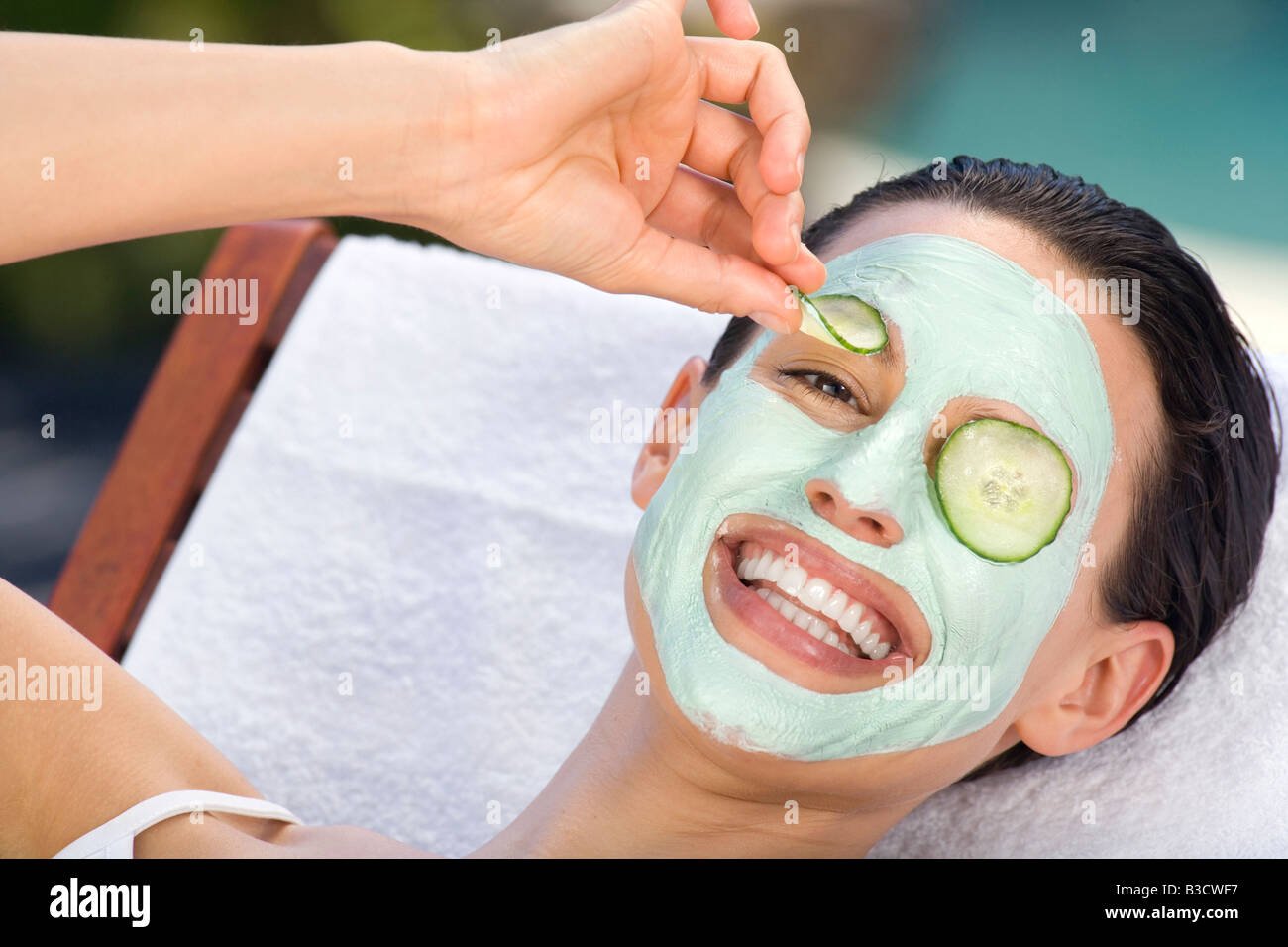 Young woman with face mask and cucumber slices, portrait Stock Photo ...