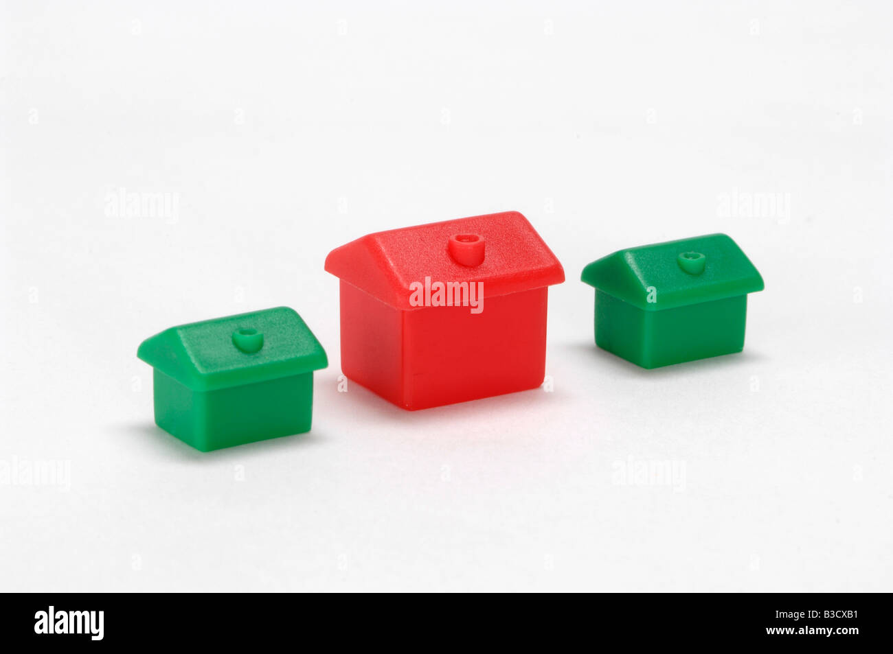 Red plastic miniature-house standing amongst green ones Stock Photo - Alamy
