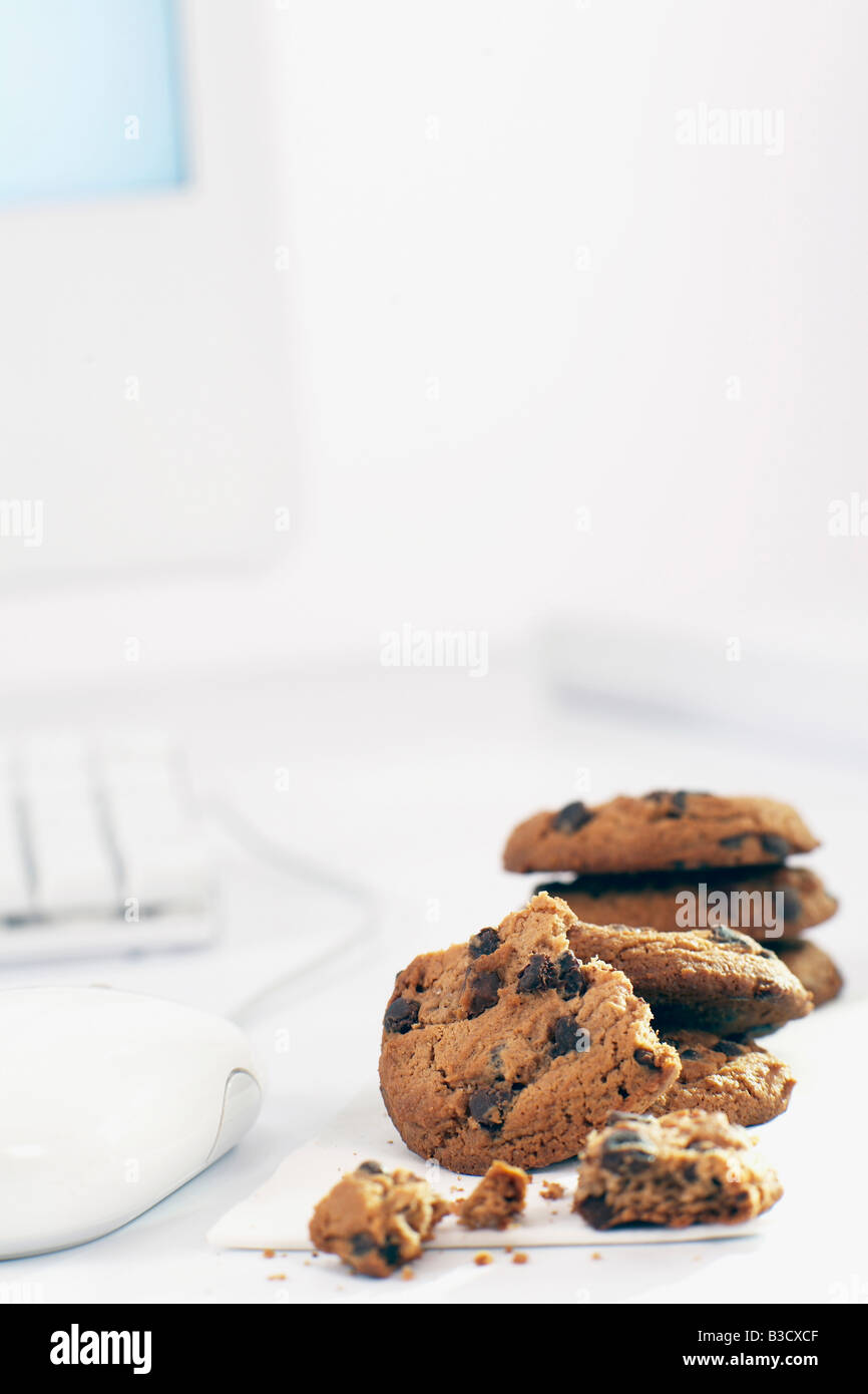 Cookies on desk alongside computer Stock Photo - Alamy