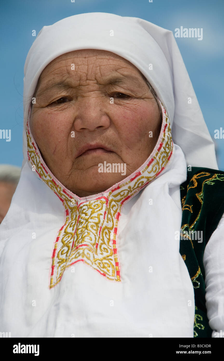 An elderly Kazakh woman wearing a traditional white head covering known ...