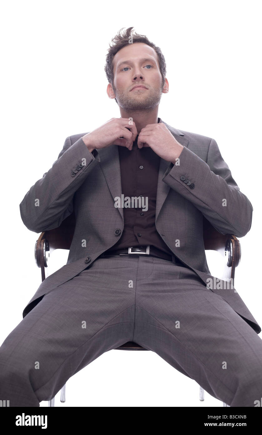 Portrait of a young man sitting on chair Stock Photo - Alamy