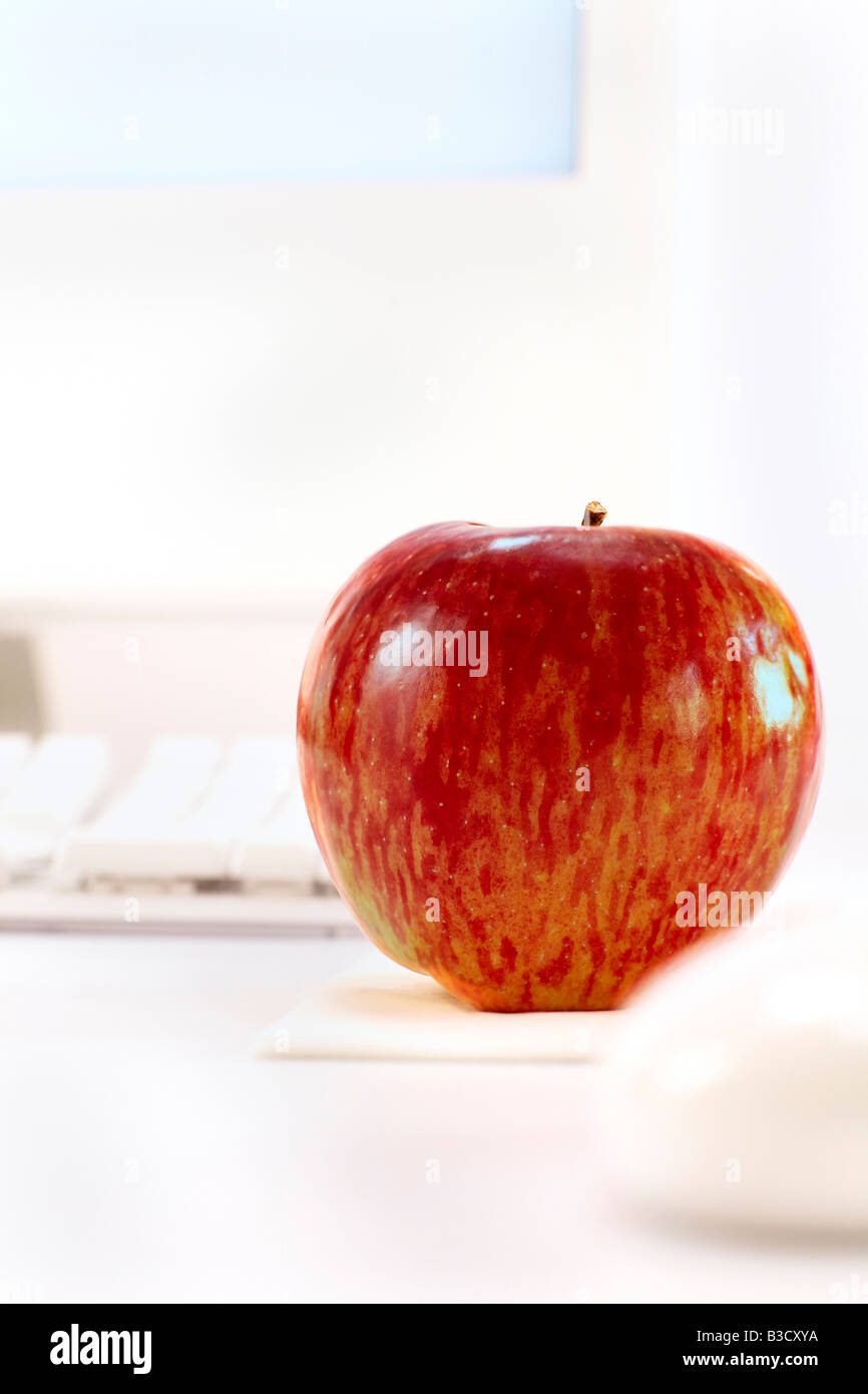 Red apple on office desk Stock Photo - Alamy