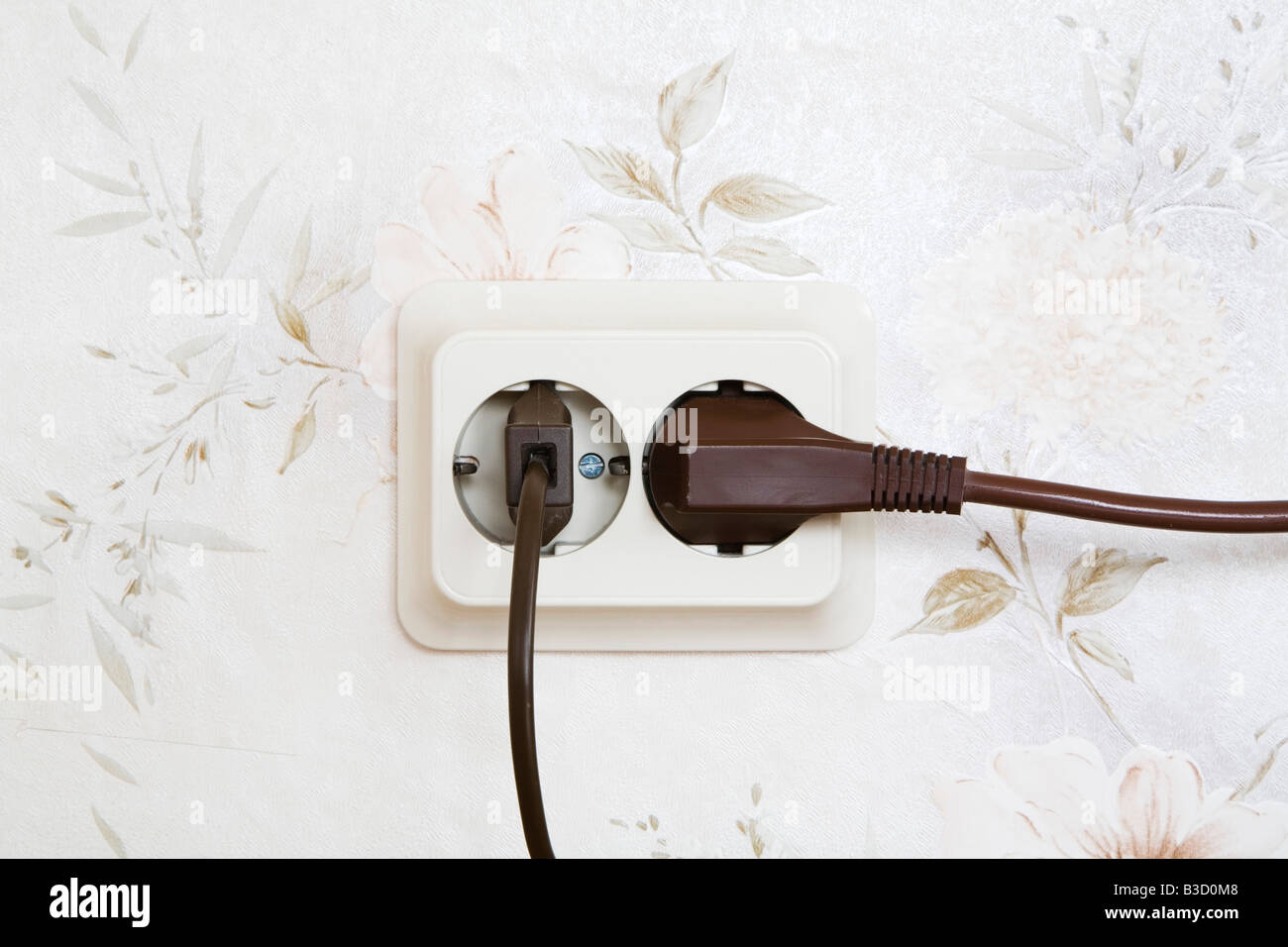 Plugs in wall socket, close-up Stock Photo - Alamy