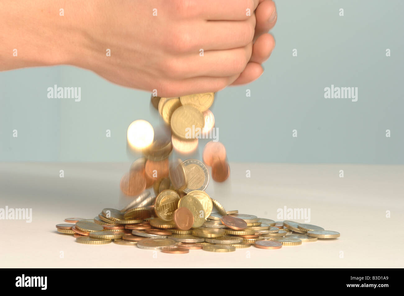 Coins falling from hands Stock Photo - Alamy