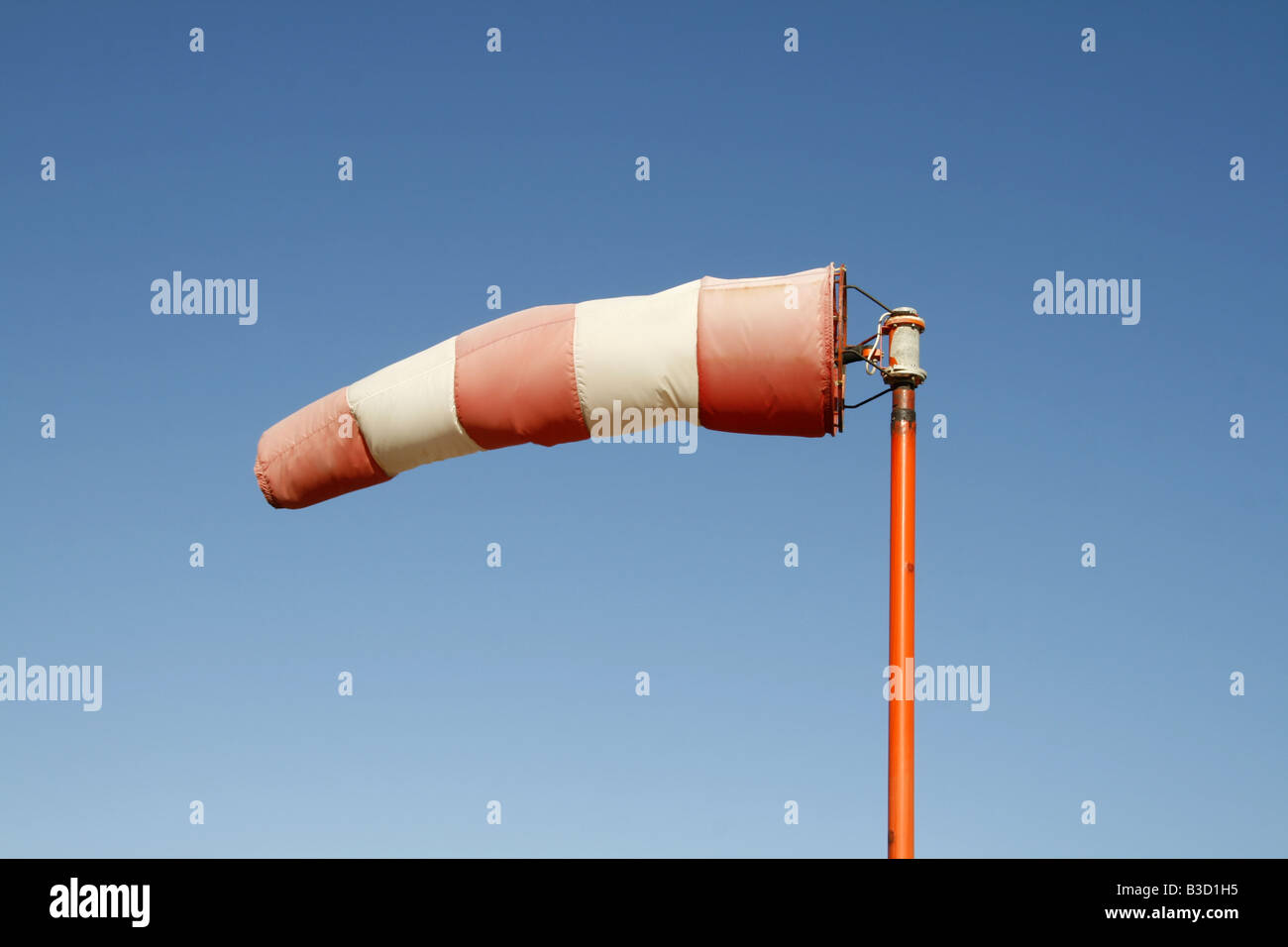 one wind sock blowing in wind at plane airport Stock Photo - Alamy