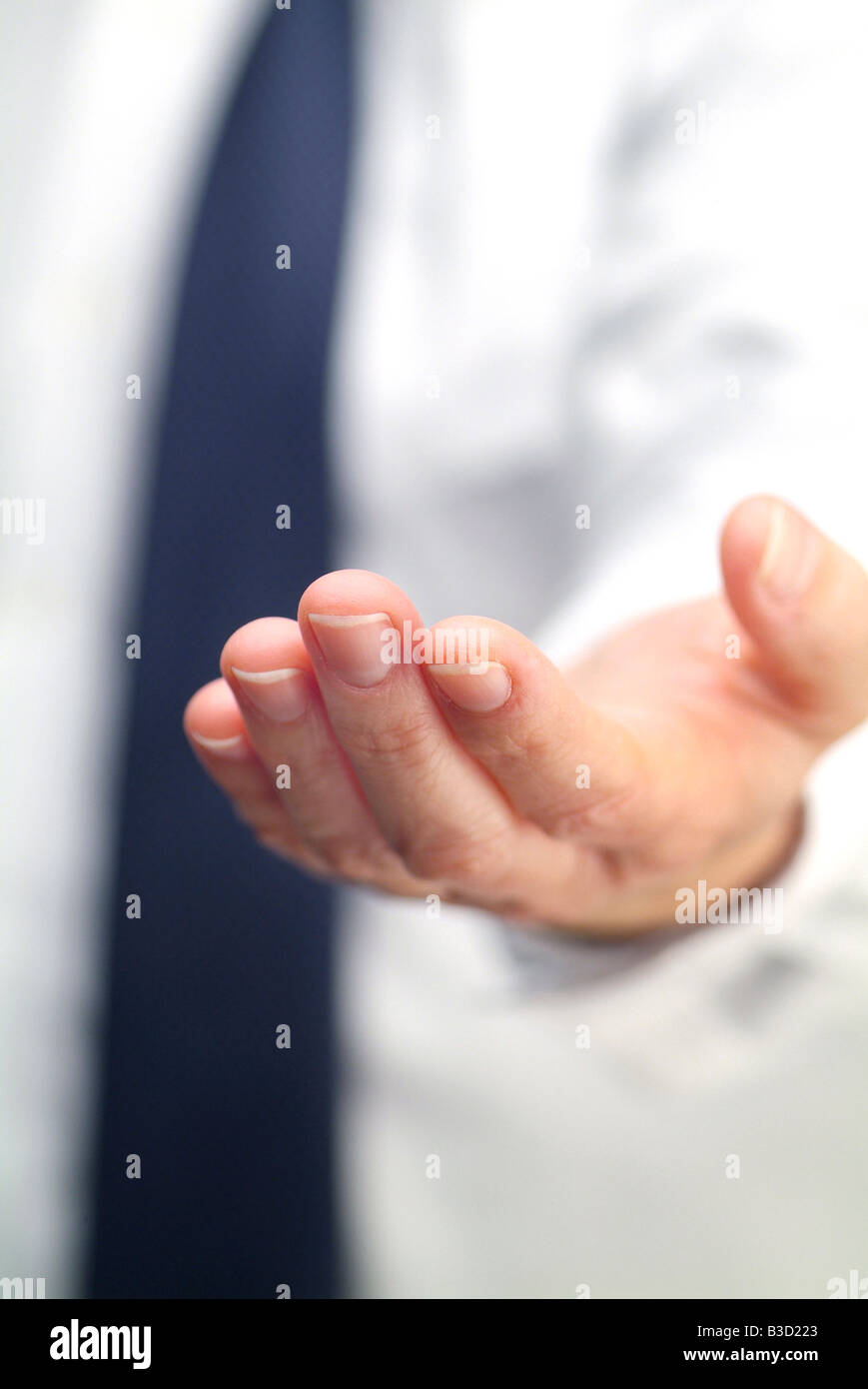 Businessman holding out an open, empty left hand towards camera Stock ...
