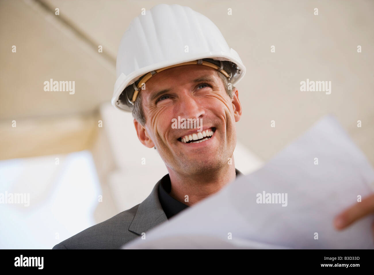 Man holding blueprint, smiling, portrait Stock Photo - Alamy