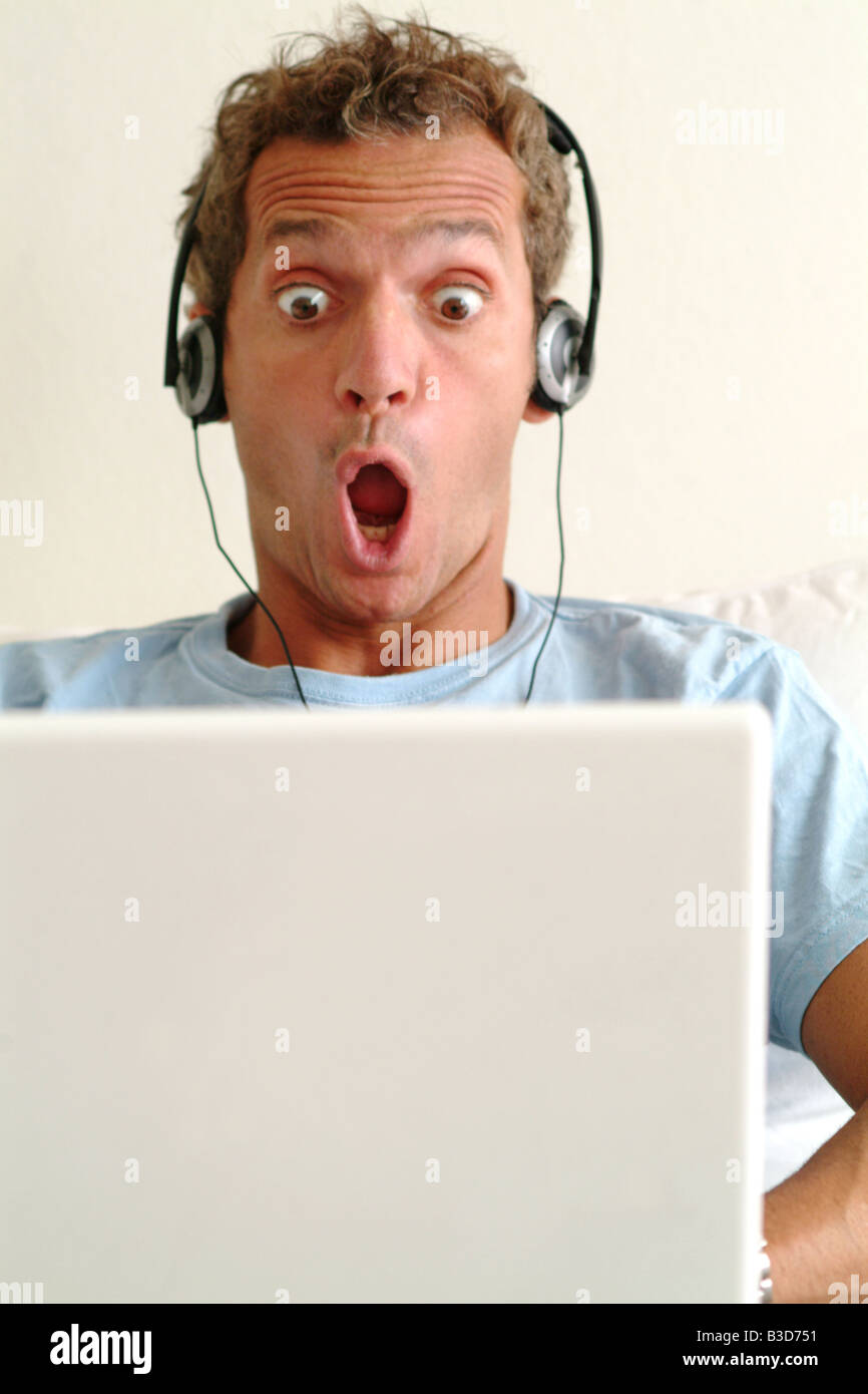 man using laptop computer looking shocked Stock Photo - Alamy