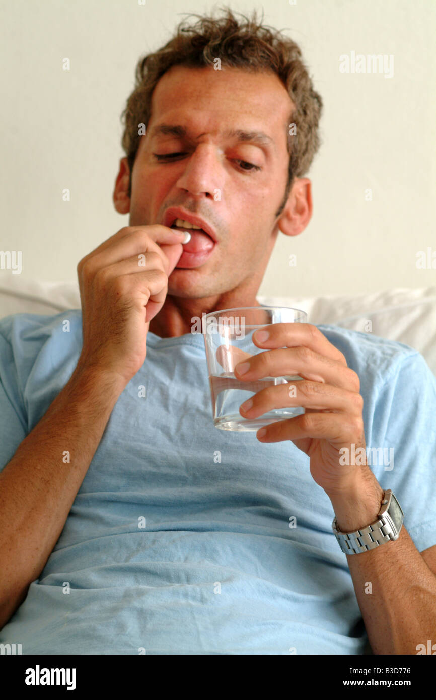 Sick black man taking medicine hi-res stock photography and images - Alamy