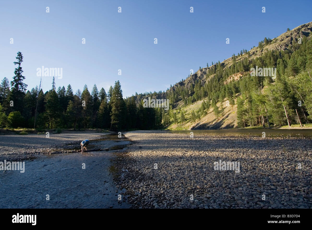 riverbed with pebbles, boy building a barrage, kettle river, british ...