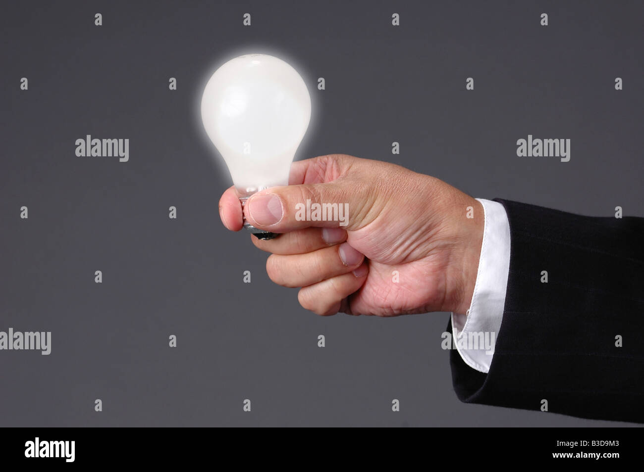Light bulb shinning at hand with neutral background Stock Photo - Alamy