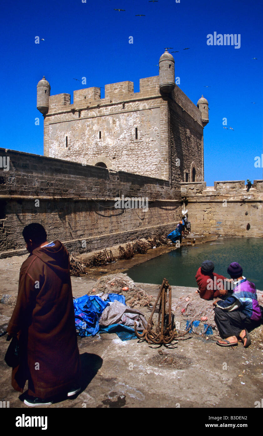 Fishermen chatting near historic defensive structures in the coastal ...