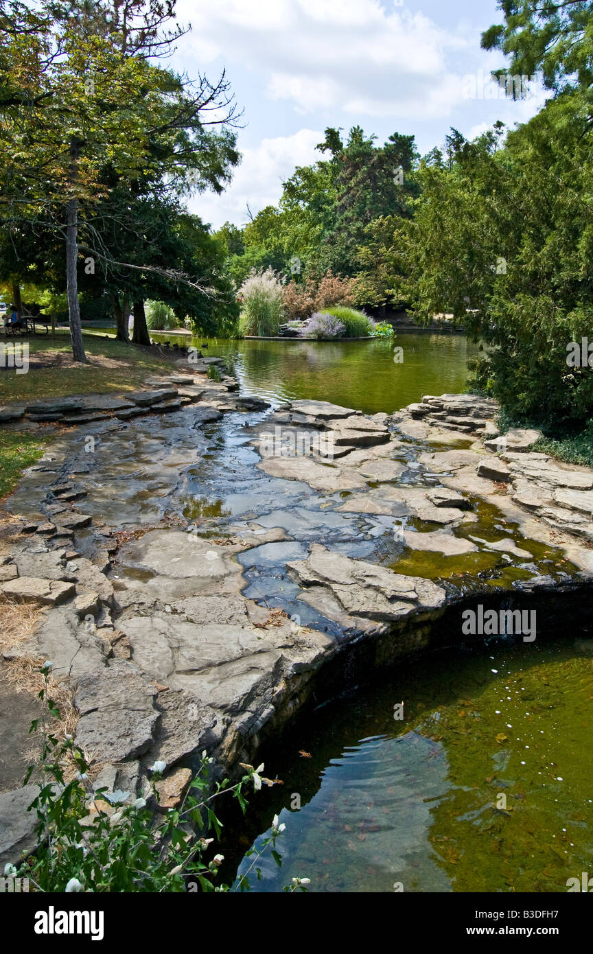 Water from a lake flowing over rocks leading into a small waterfall ...