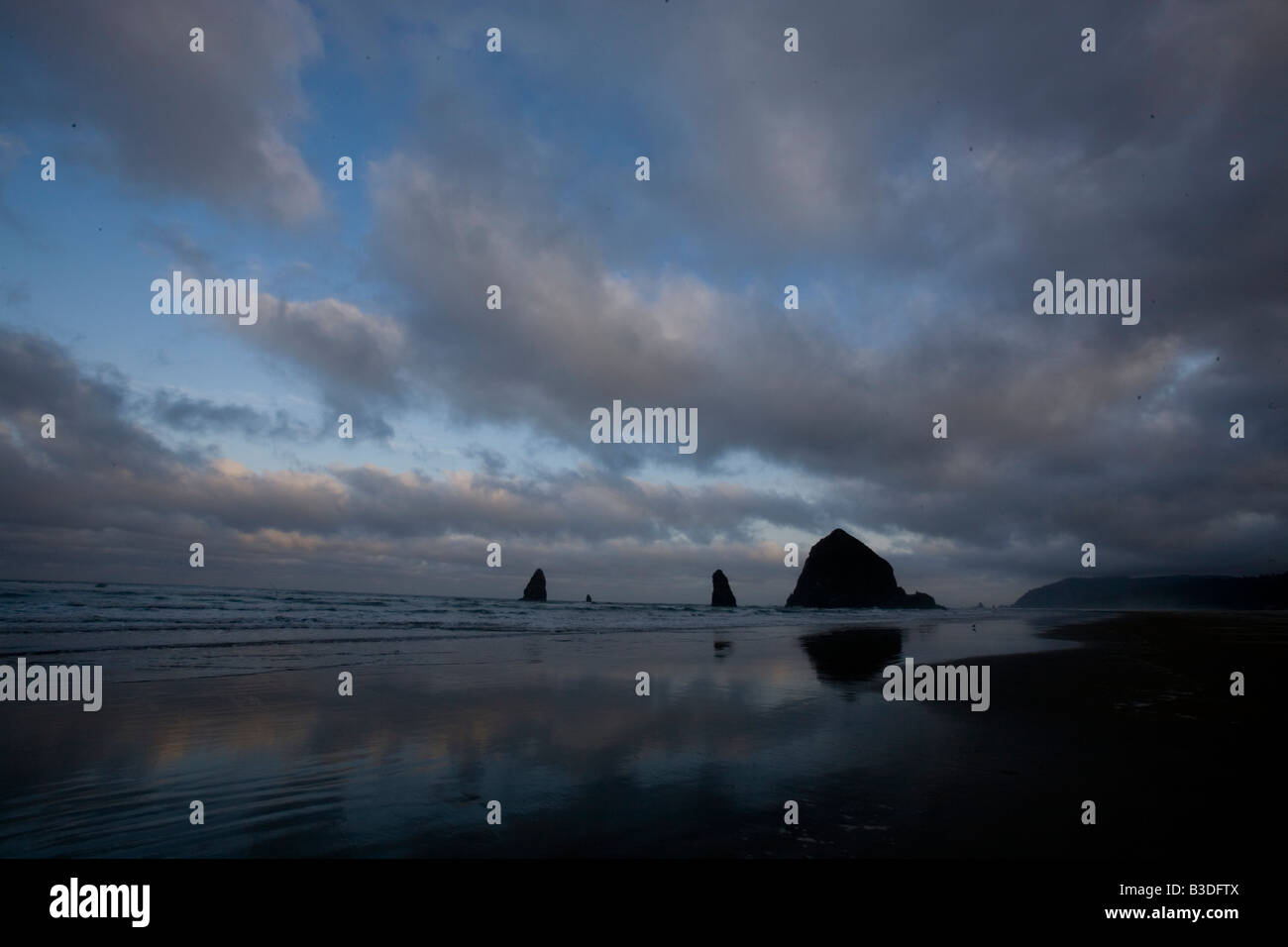 Sunrise and sea stacks on the beach in Cannon Oregon with a dramatic ...