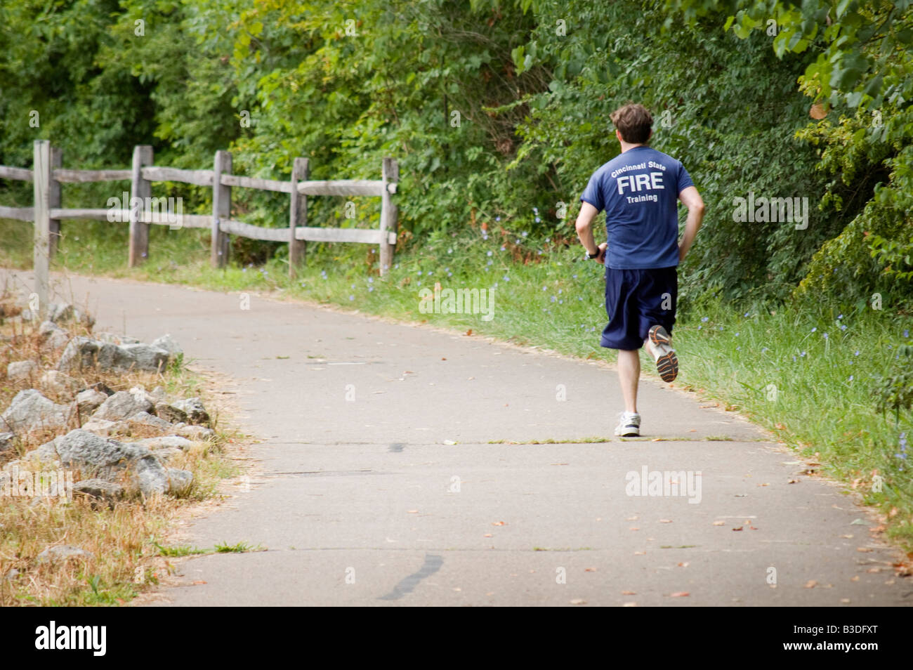 Young man running on a paved trail for exercise Stock Photo - Alamy