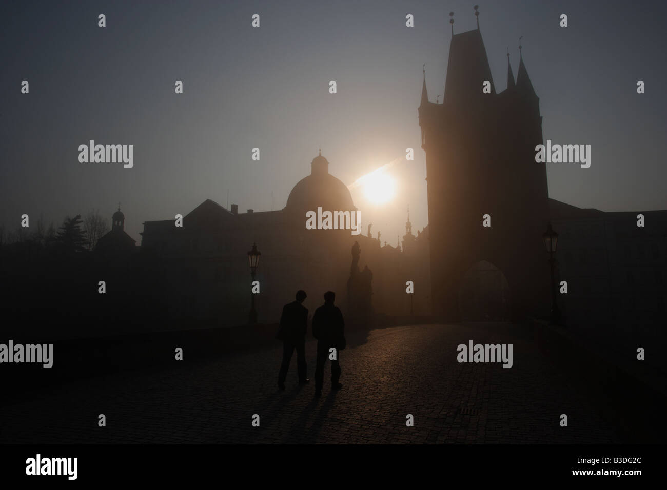 Pedestrians walk across the historic Charles Bridge, Prague with rows of Baroque statues ...