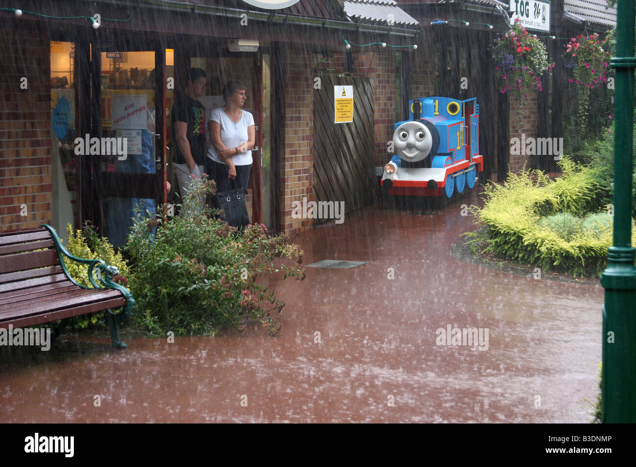 Very heavy fall of rain causing people to seek cover in a shopping ...
