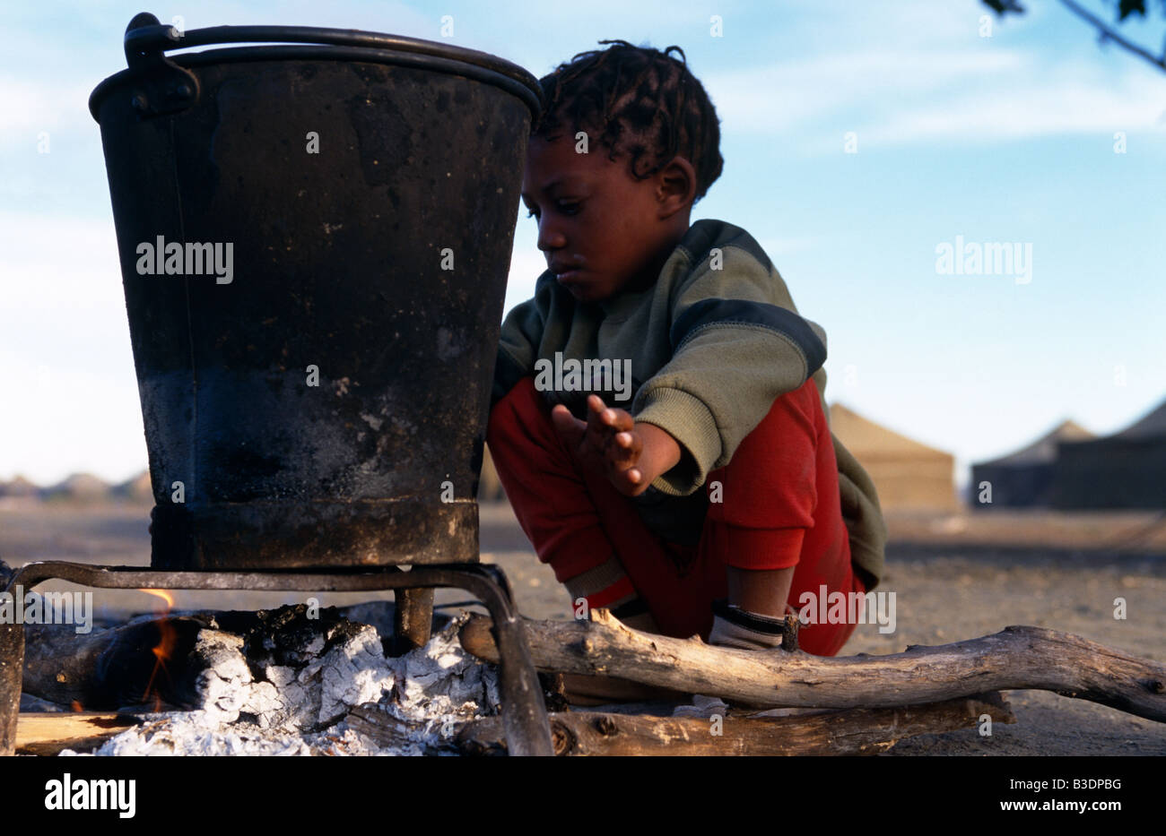 Boy playing with fire, Schmidtsdrift camp, Northern Cape, South Africa ...