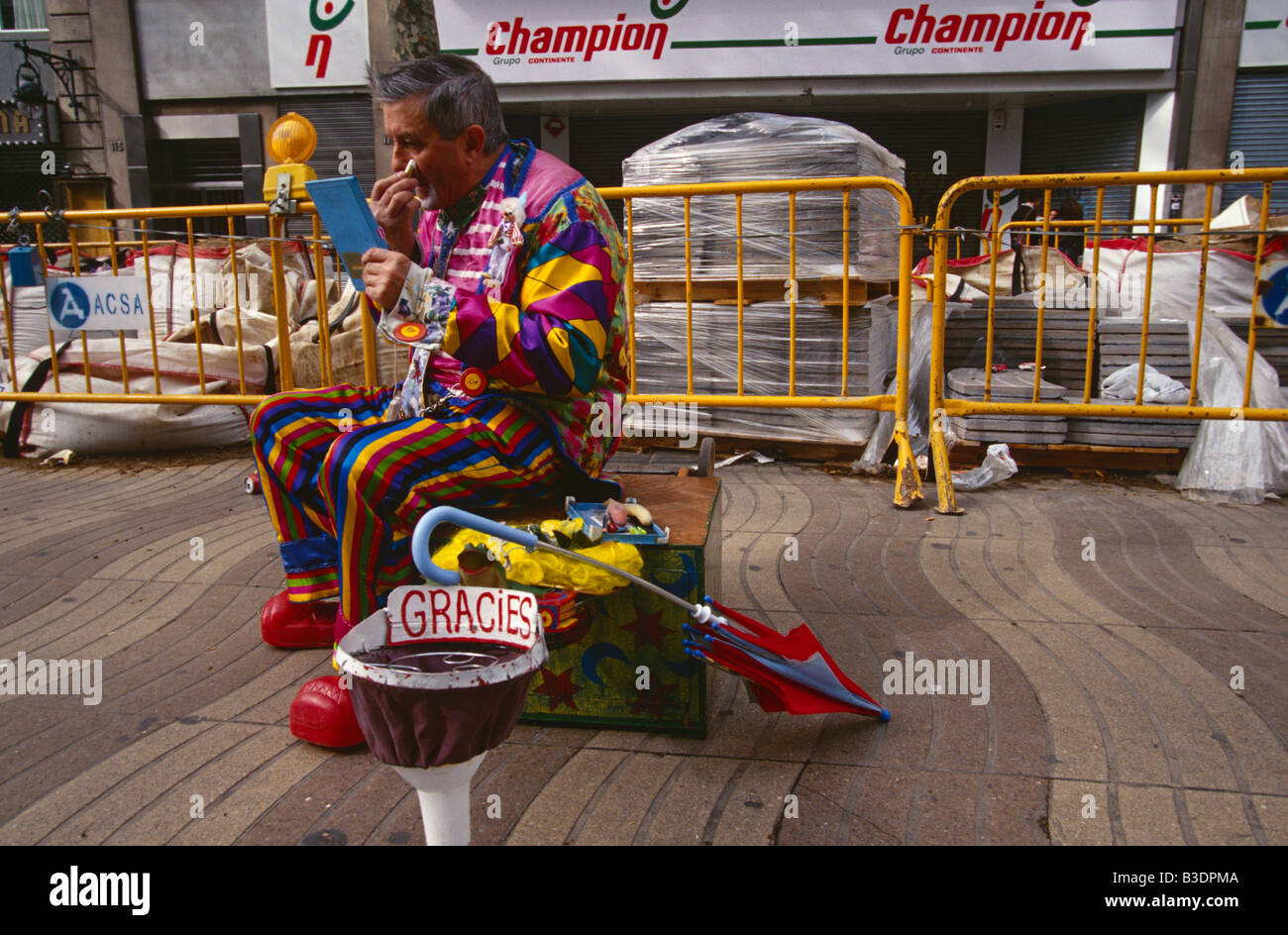Street artist in clown costume preparing for performance, Barcelona ...