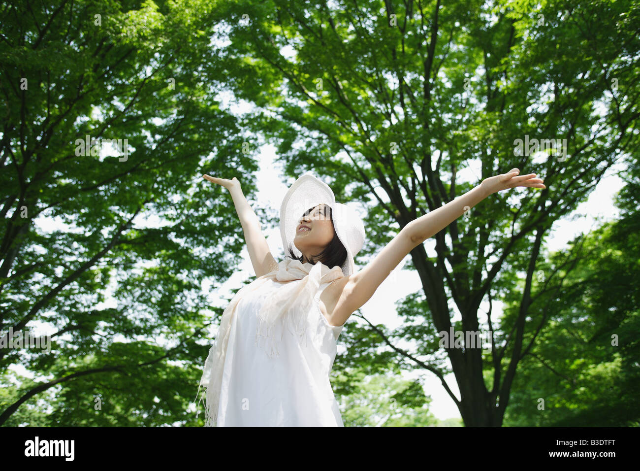 A young woman looking at green trees Stock Photo - Alamy