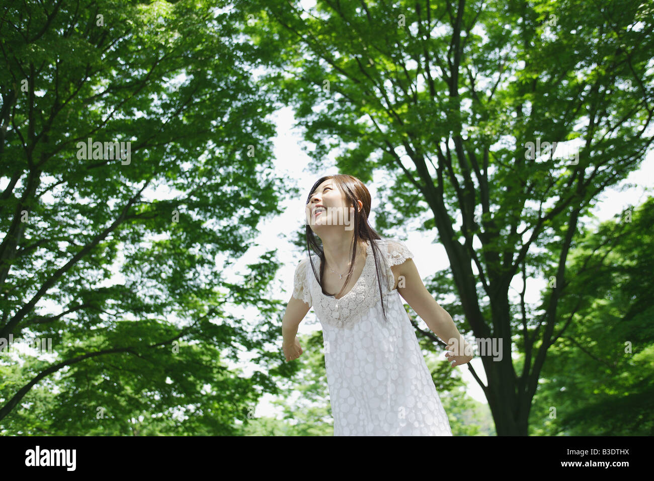 A young woman looking at green trees Stock Photo - Alamy