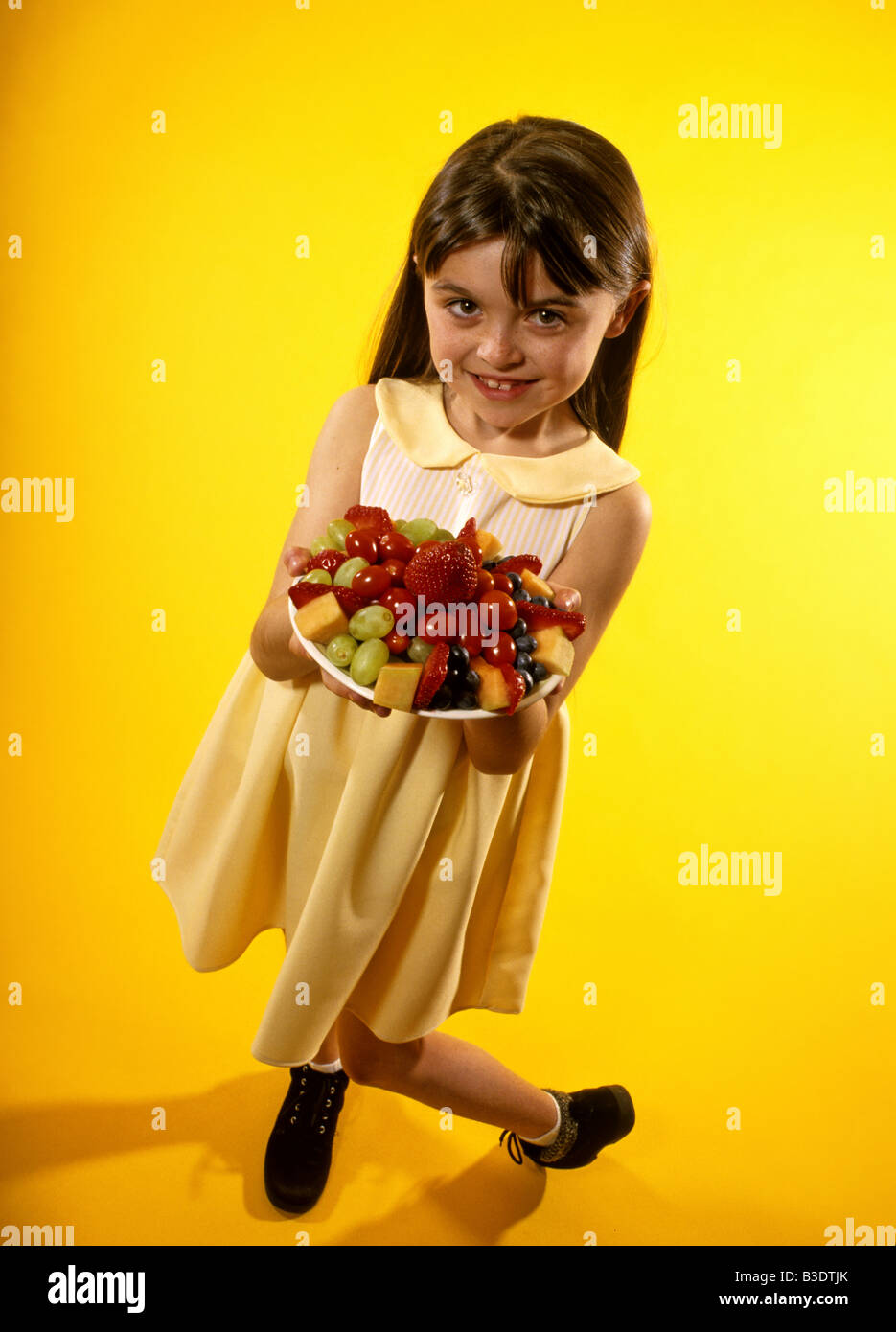 Girl with plate full of fruits Stock Photo - Alamy