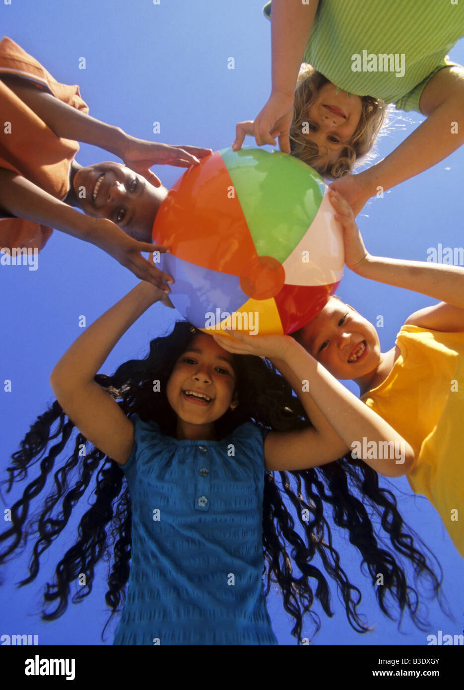 2 boys 2 girls friends together from below with ball Stock Photo - Alamy