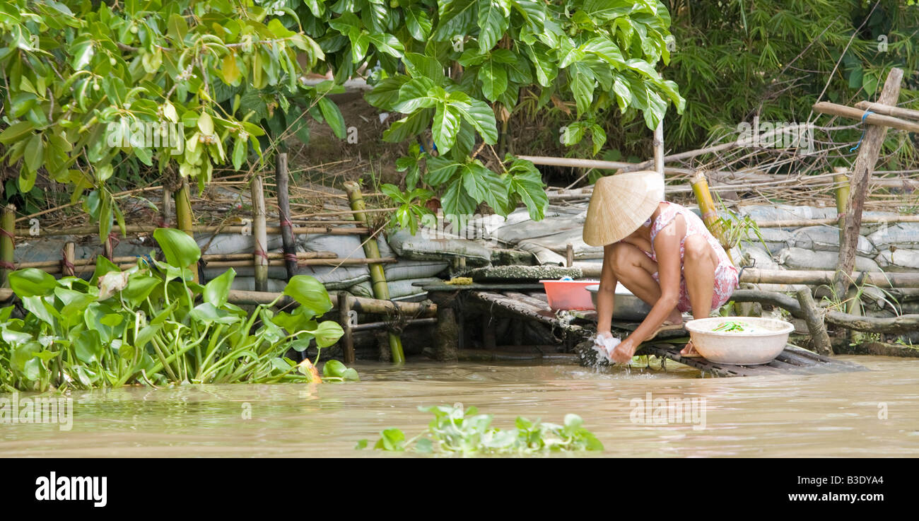 A Vietnamese woman cleaning and preparing food in the Mekong Delta ...