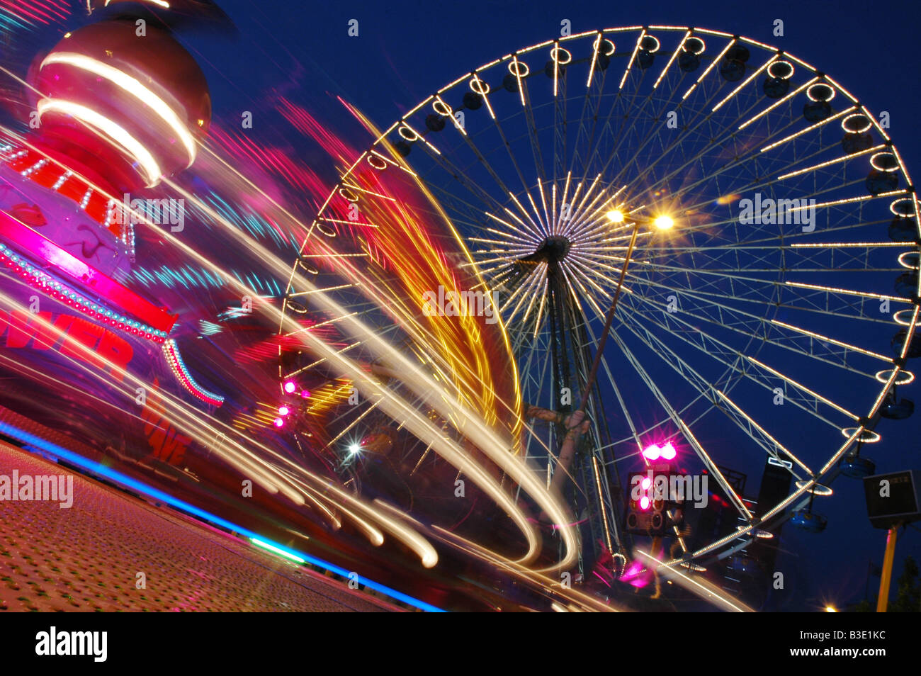 colourful fairground with ferris wheel at dusk Stock Photo - Alamy
