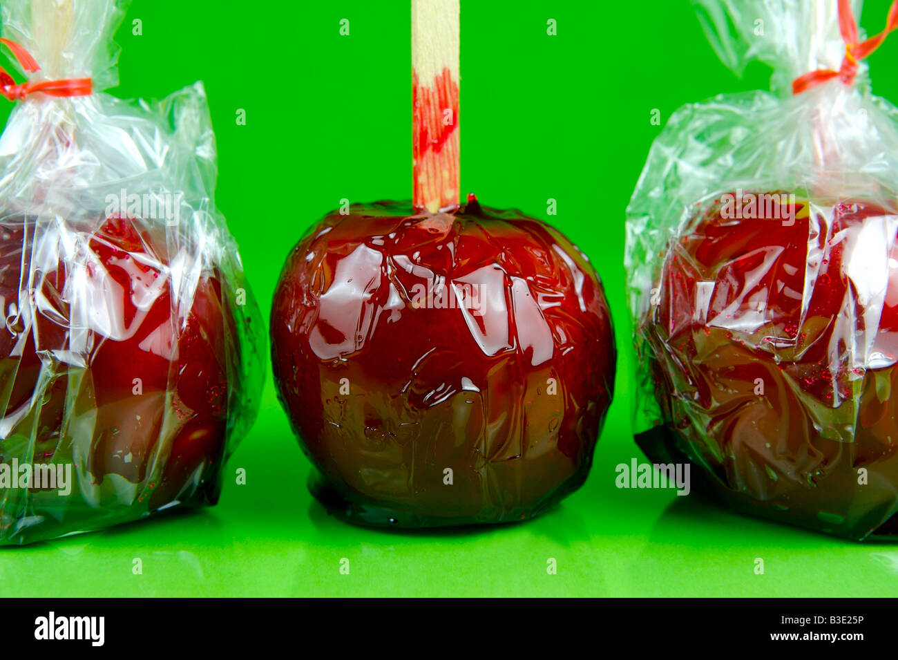 Candy apples isolated against a green background Stock Photo - Alamy