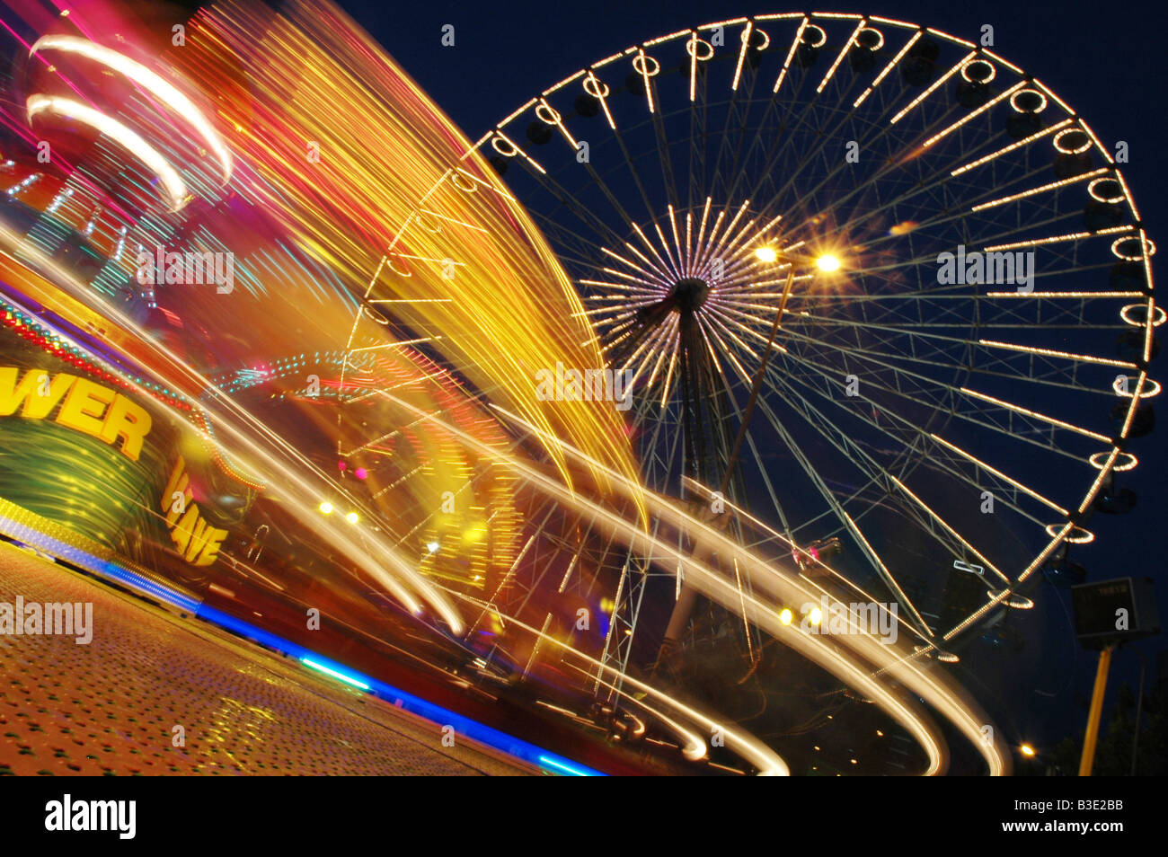 colourful fairground with ferris wheel at dusk Stock Photo - Alamy