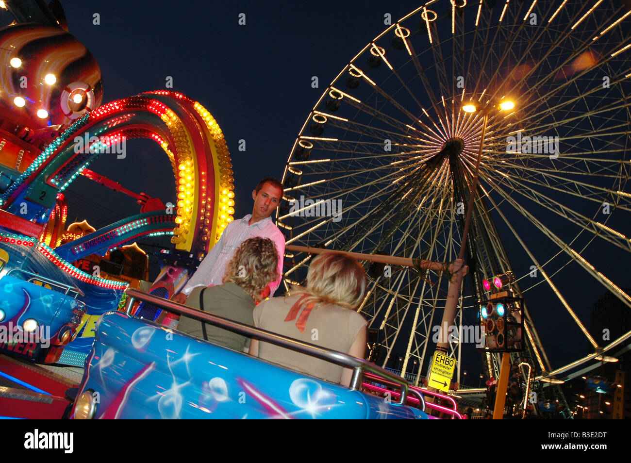 colourful fairground ride with ferris wheel at dusk Stock Photo - Alamy