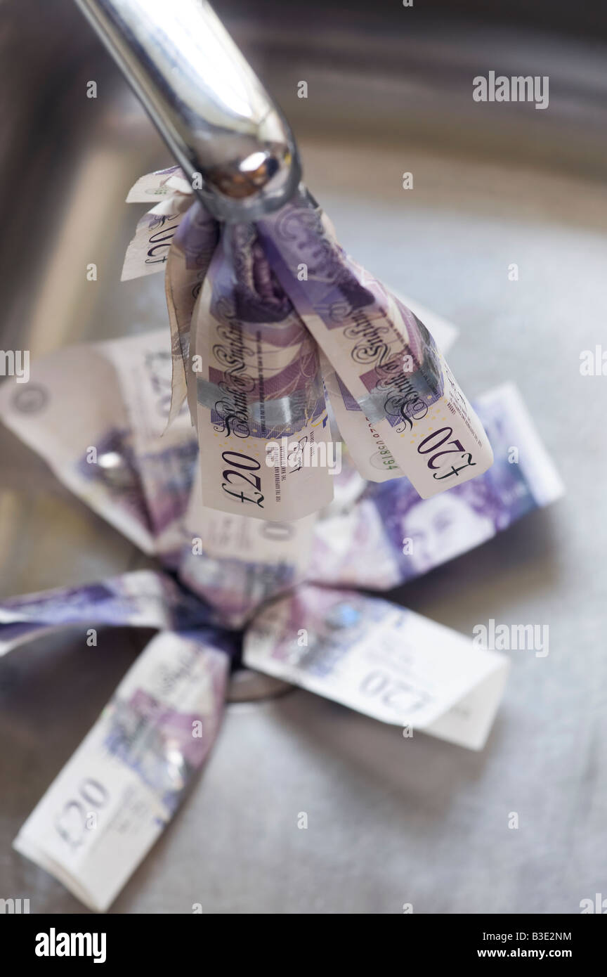Pouring money down the drain concept Stock Photo - Alamy