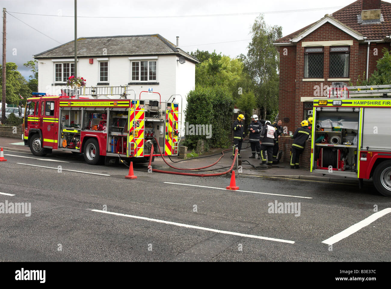 Fire Brigade Resting After Dealing With A House Fire Stock Photo - Alamy