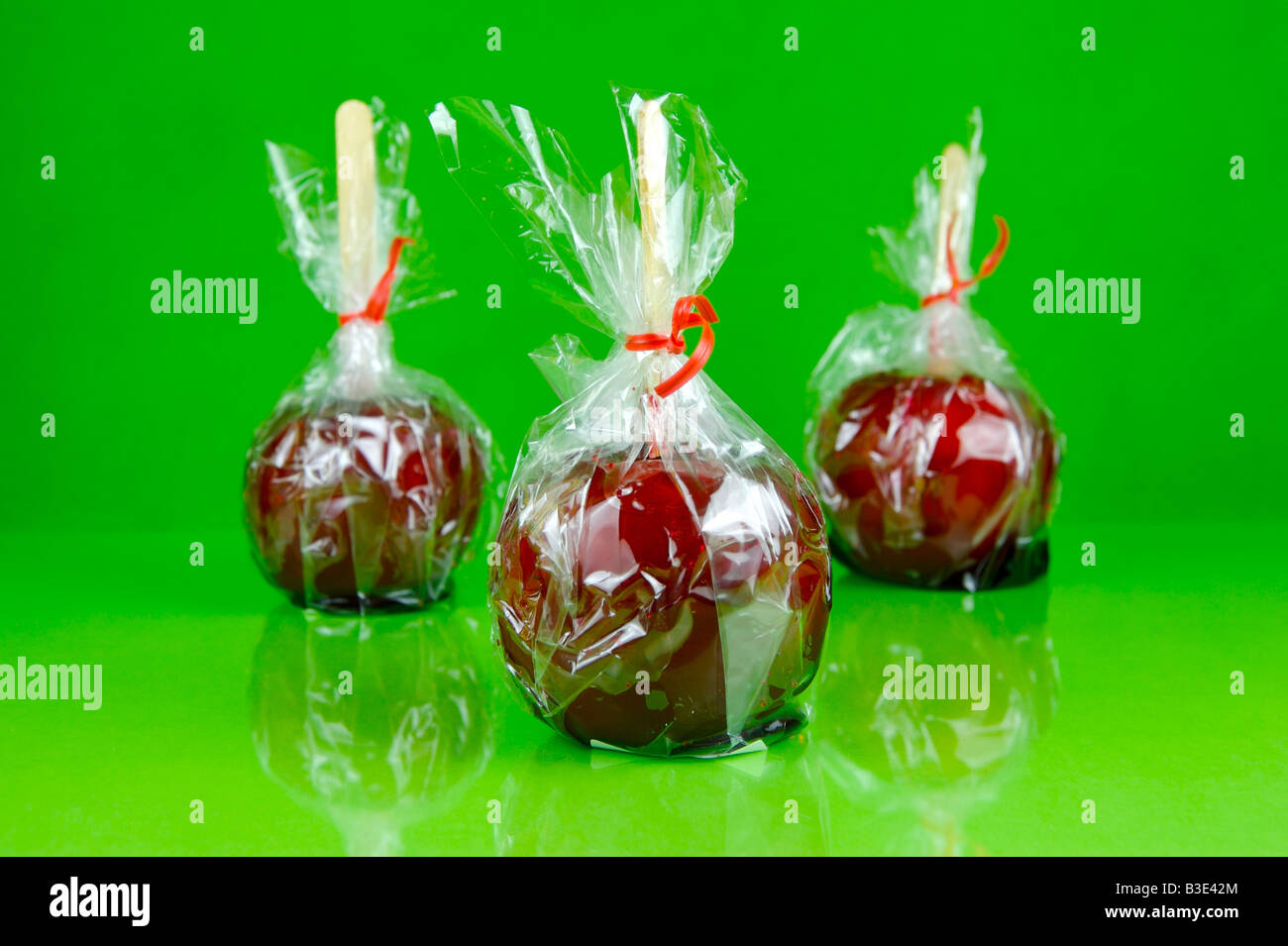 Candy apples isolated against a green background Stock Photo - Alamy