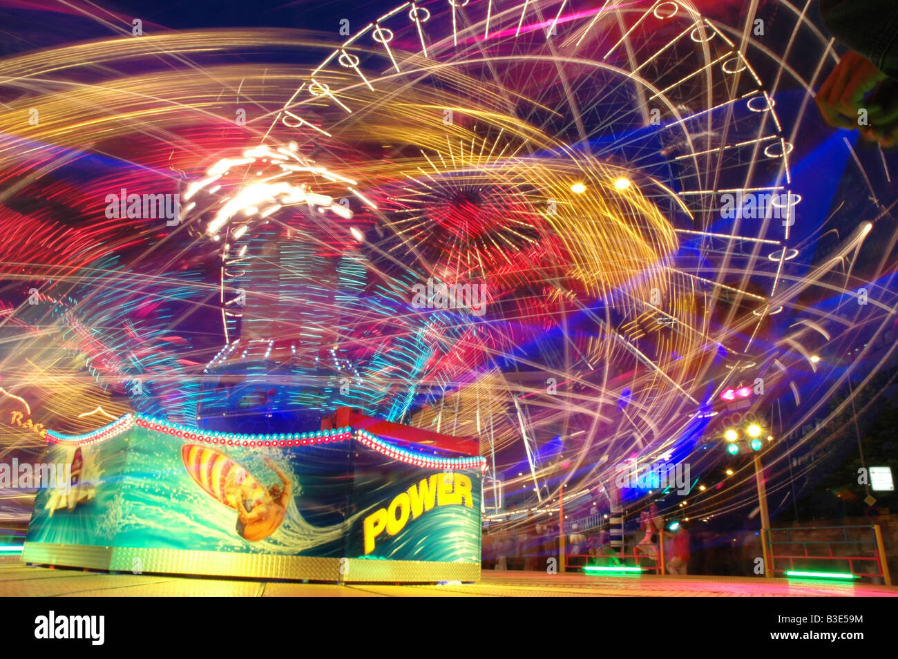 colourful fairground ride with ferris wheel at dusk Stock Photo - Alamy