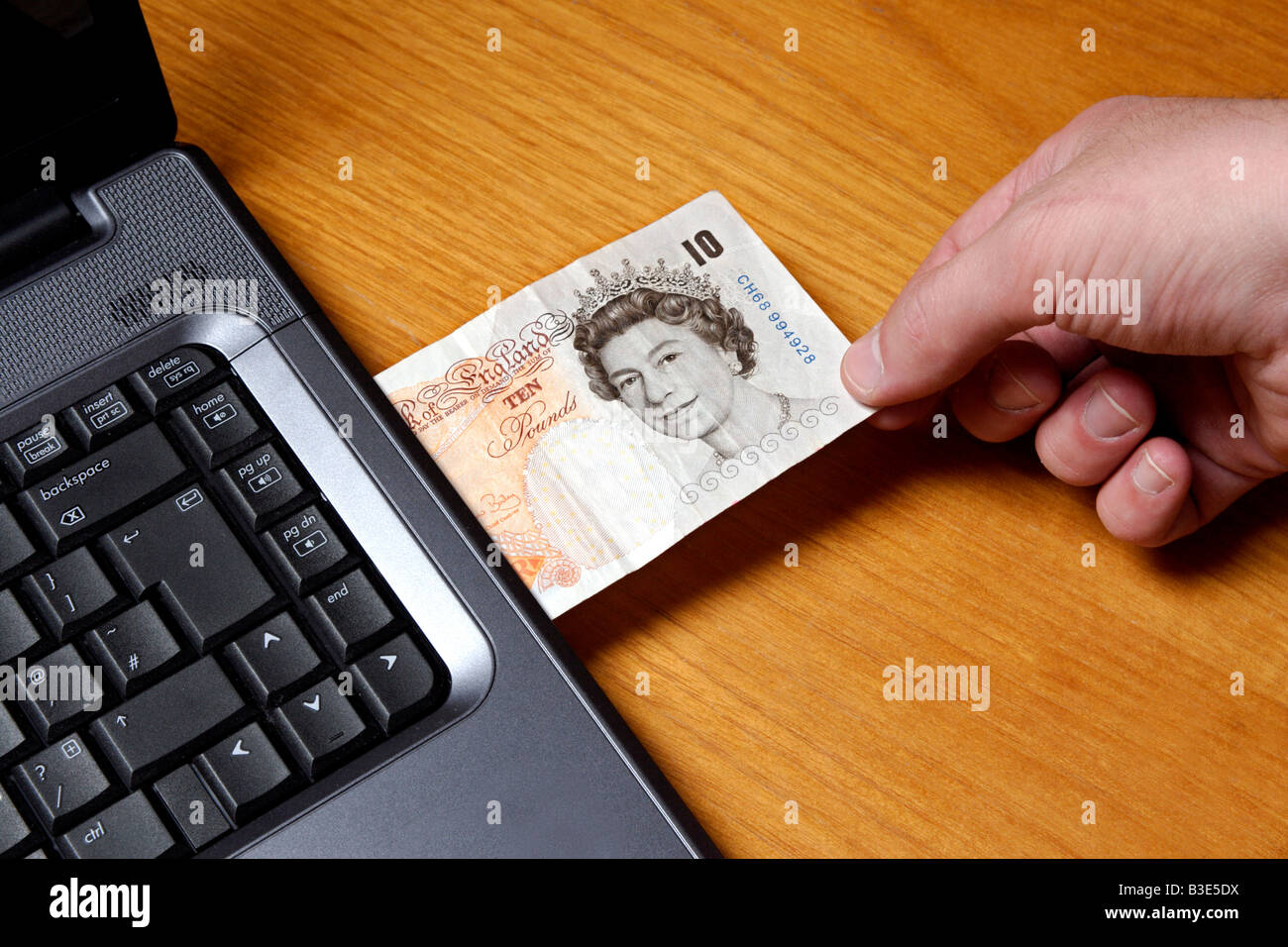 Person taking cash from laptop computer close up Stock Photo - Alamy