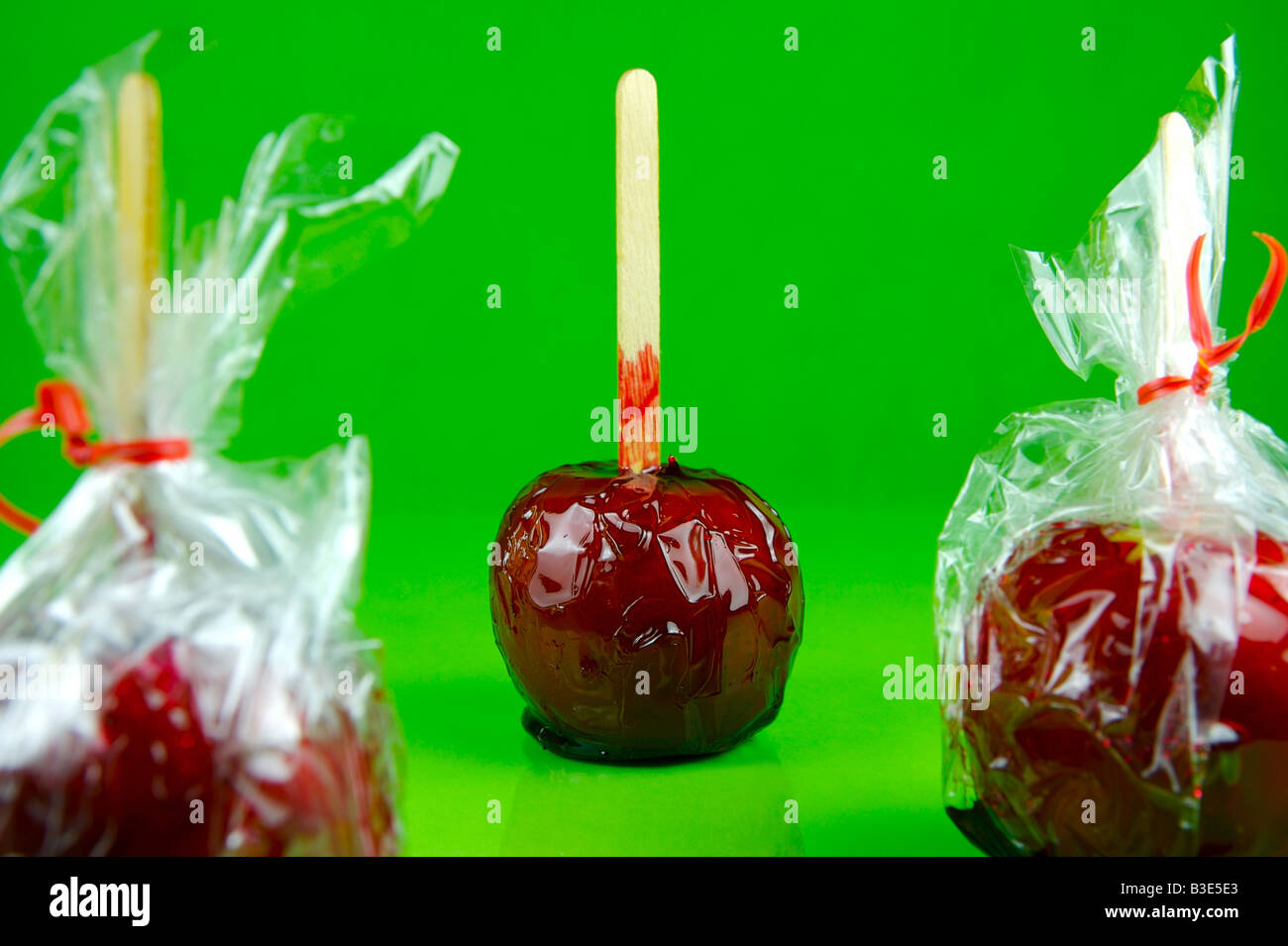 Candy apples isolated against a green background Stock Photo - Alamy