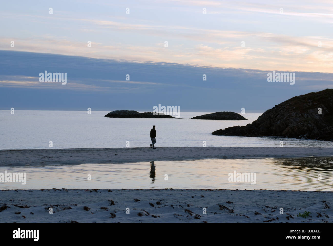 Man walking on an empty beach Andenes island of Andoya Northern Norway ...