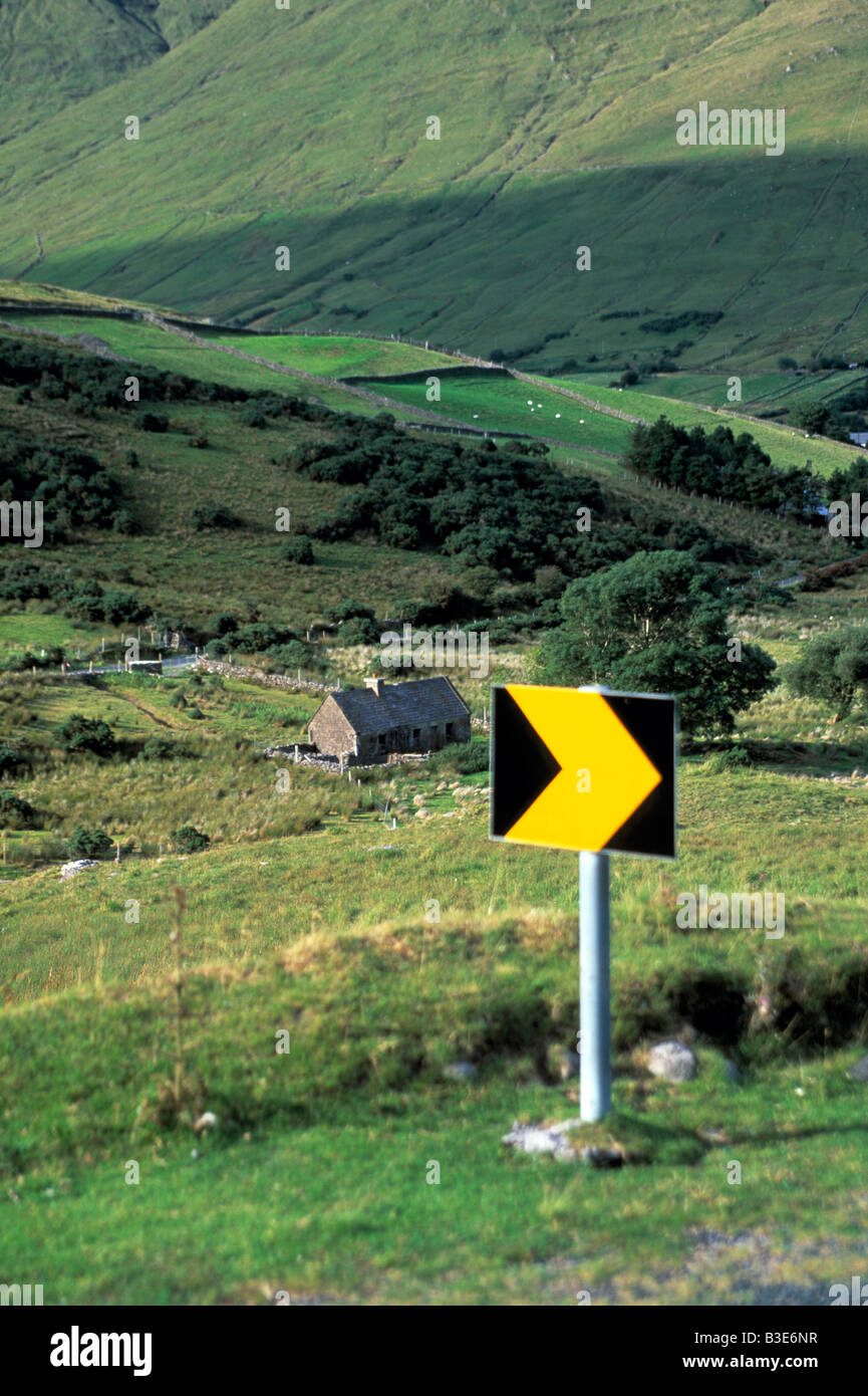 black and yellow reflective road sign warning of the direction of the ...