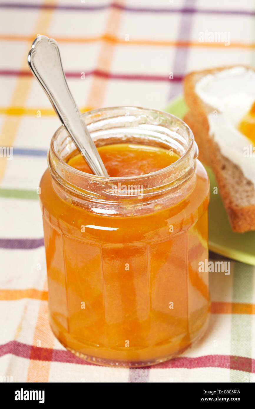 Toast with butter and peach jam glass jar in the green plate with soft ...