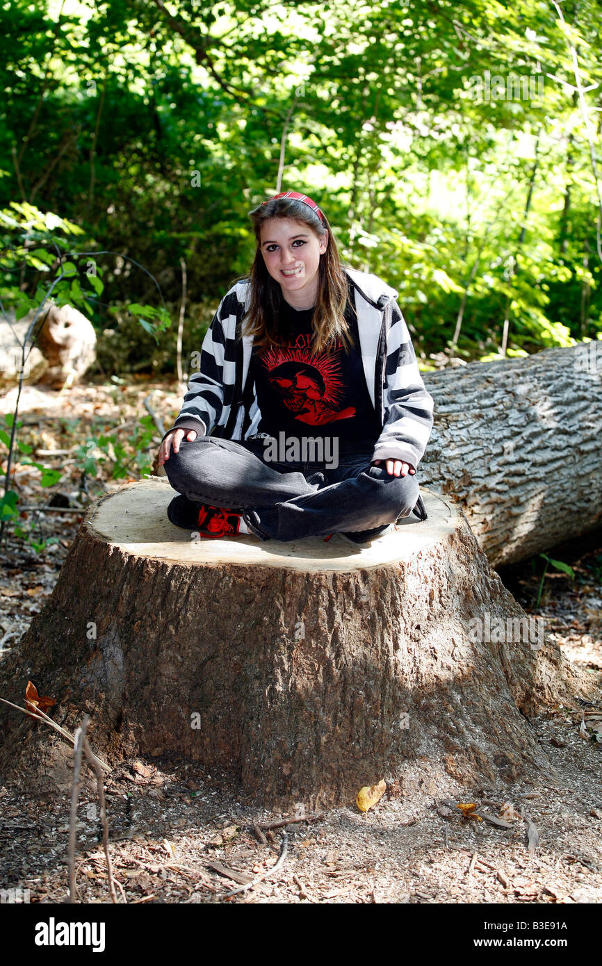 Woman sitting on a giant tree stump cross legged Stock Photo - Alamy