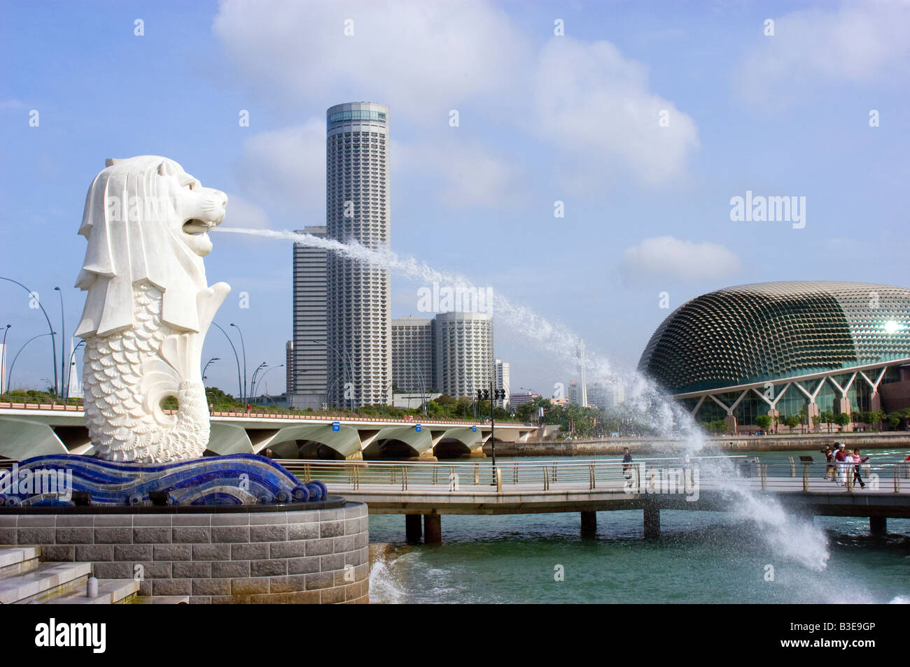 The Singapore Merlion spouts water into Marina Bay, with the Stamford ...
