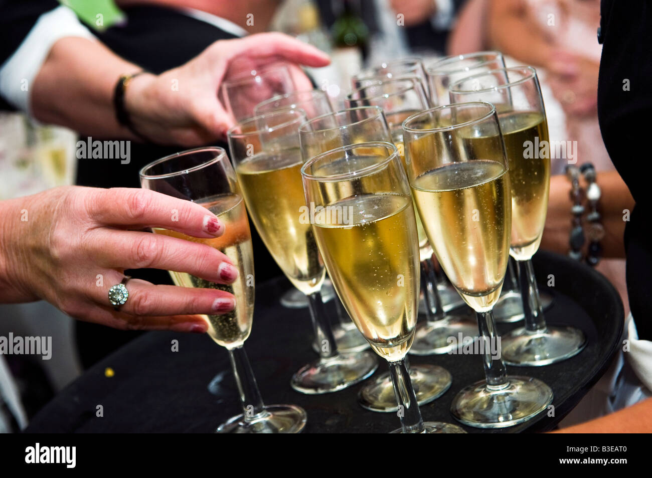 A tray with glasses of champagne being passed around Stock Photo - Alamy