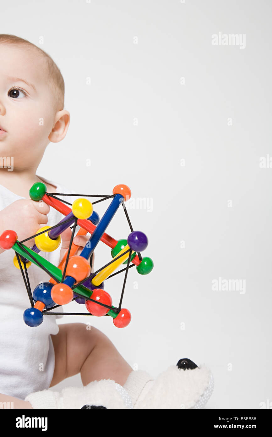 A baby holding a toy Stock Photo - Alamy