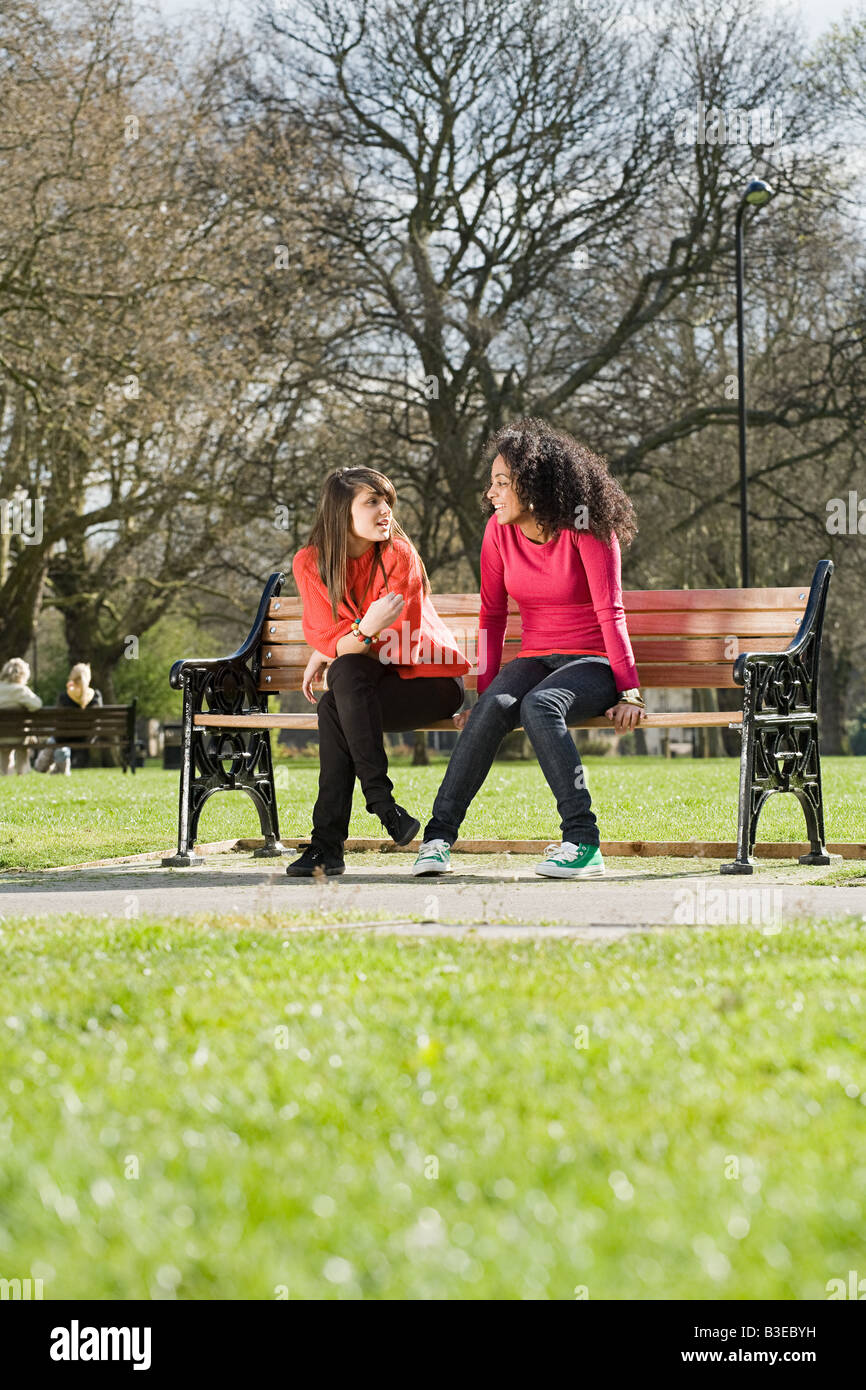 Girls sitting on a bench Stock Photo - Alamy